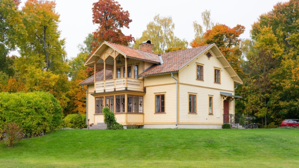 Hus i 1800-talsstil i topp före gård med kungakoppling